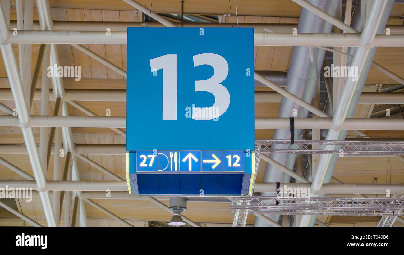 A number 13 lane number sign on the ceiling indicating that it is the ...
