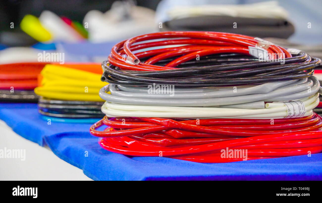 Rolled colored wires on the table there are red white and blue color ...