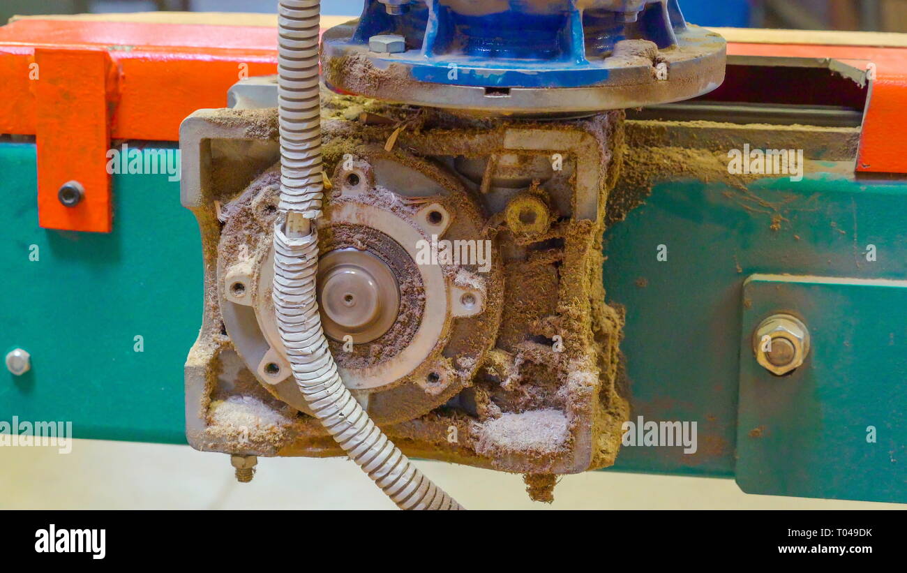 The motor of a running machine in the sawmill with lots of sawdust ...