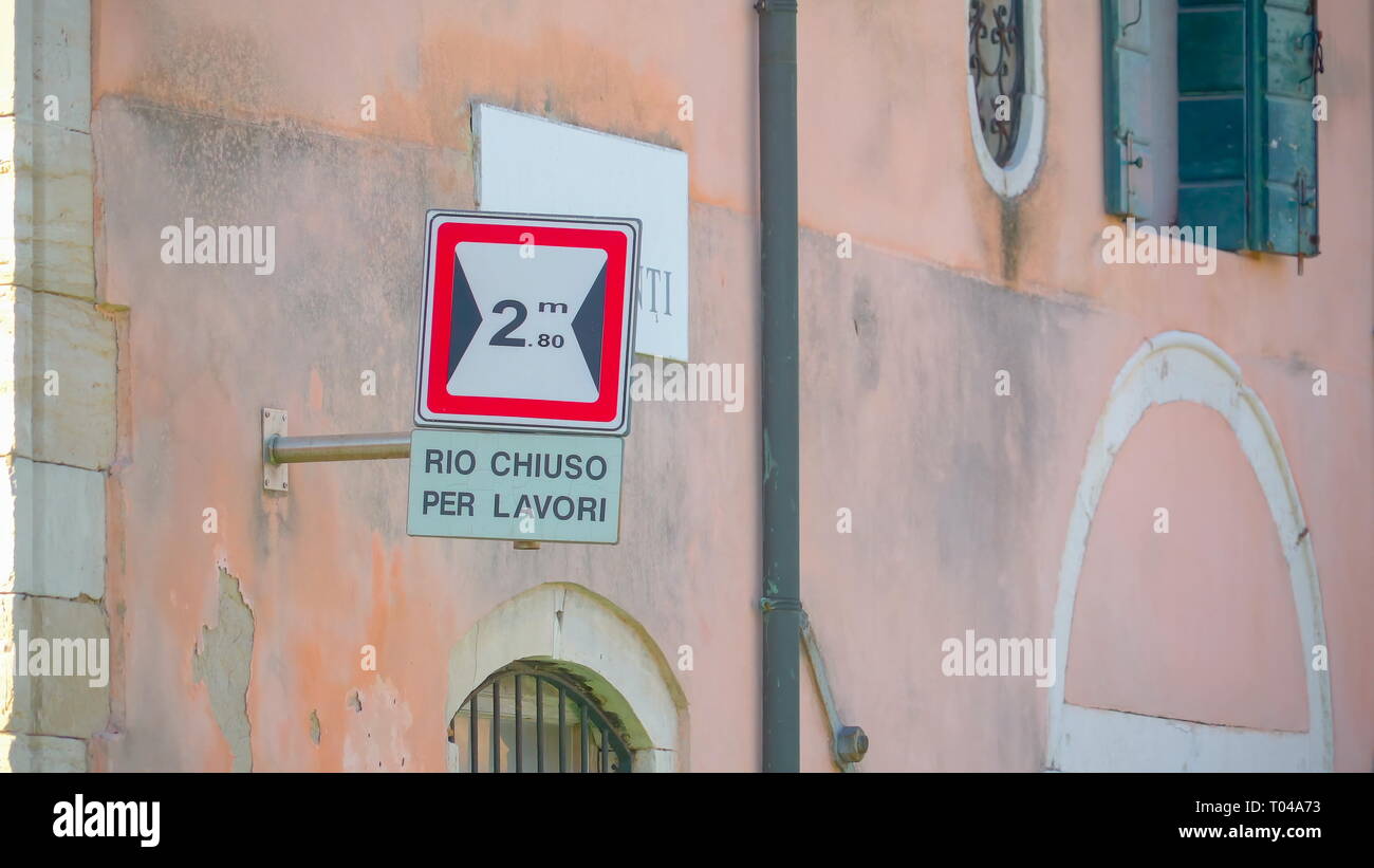 The signage on the wall of the pink building in the middle of the canal ...