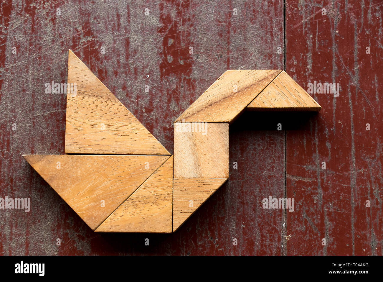 Tangram puzzle in swan shape on red old wood background Stock Photo - Alamy