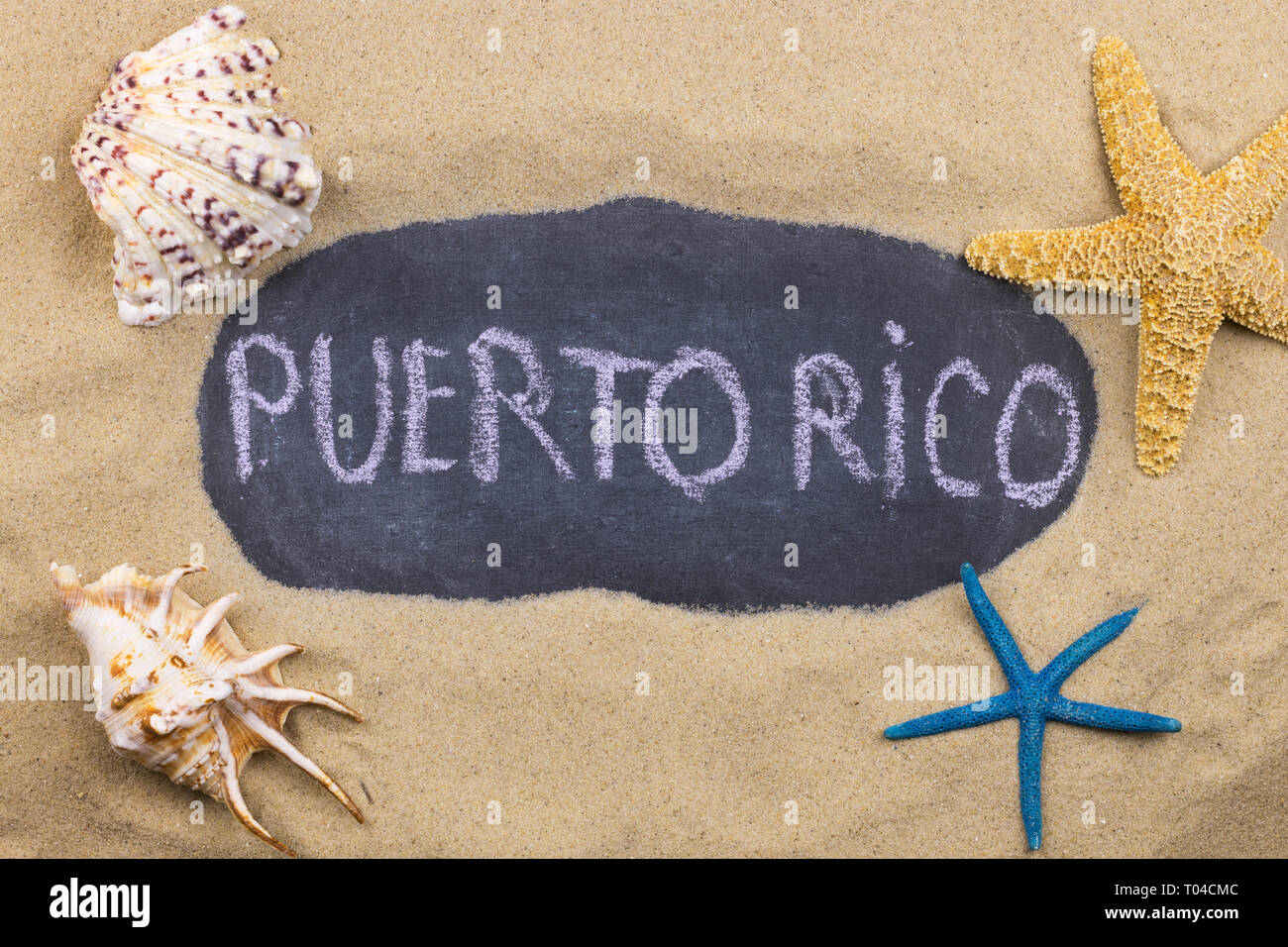 Handwritten word PUERTO RICO written in chalk, among seashells and ...