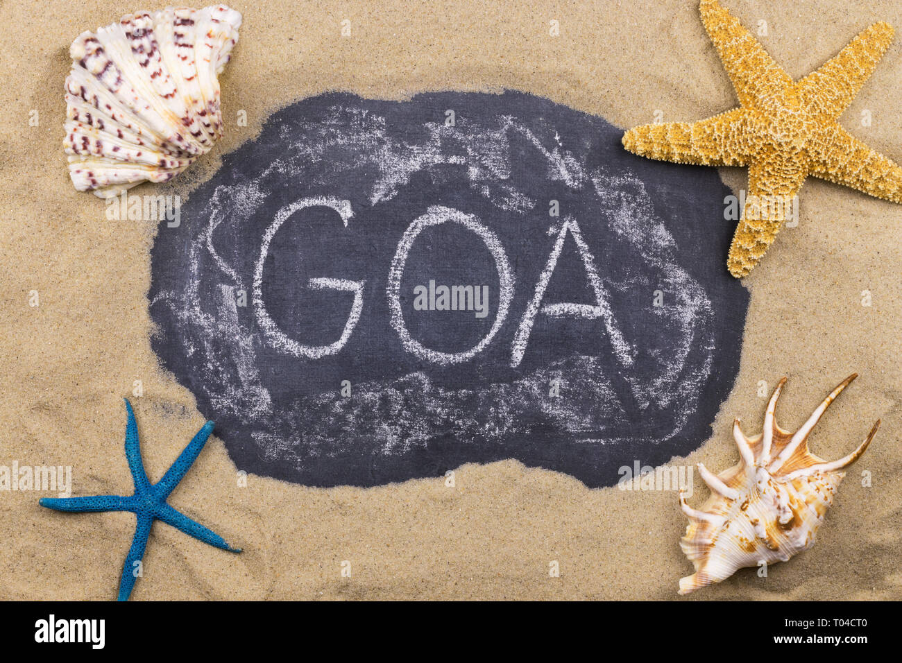 Handwritten word GOA written in chalk, among seashells and starfishes ...