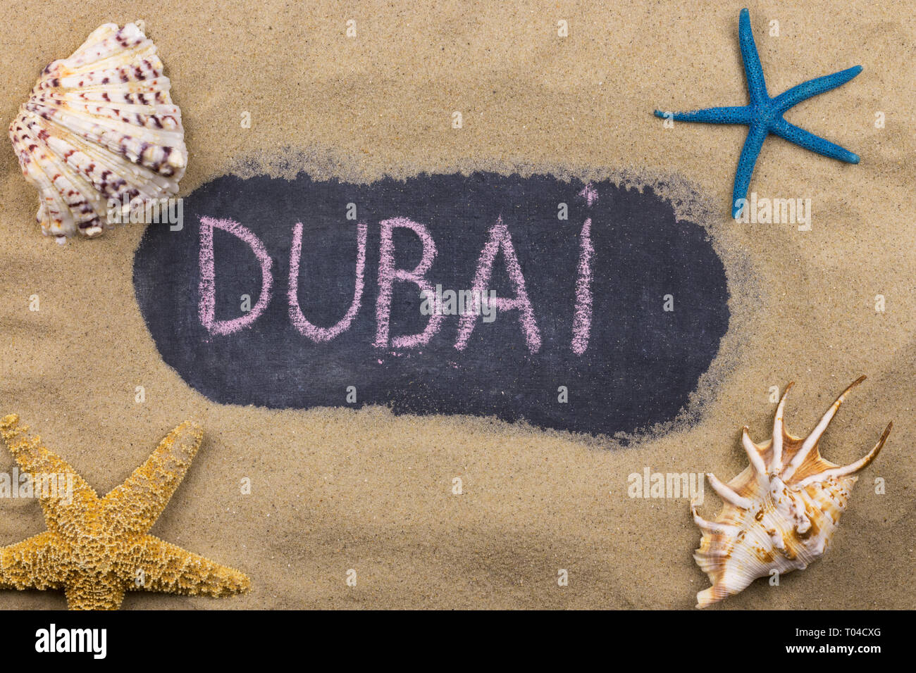 Handwritten word DUBAI written in chalk, among seashells and starfishes ...