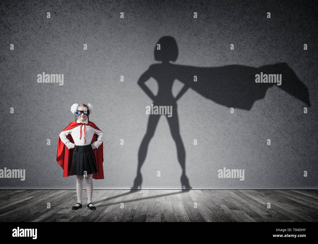 Girl power concept with cute kid guardian and shadow at wall. Mixed ...