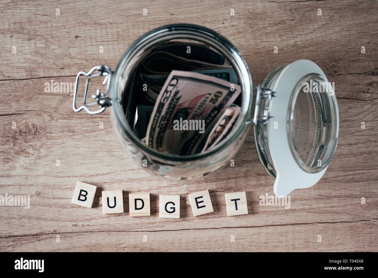 word budget made of wooden blocks and glass jar filled with dollar ...