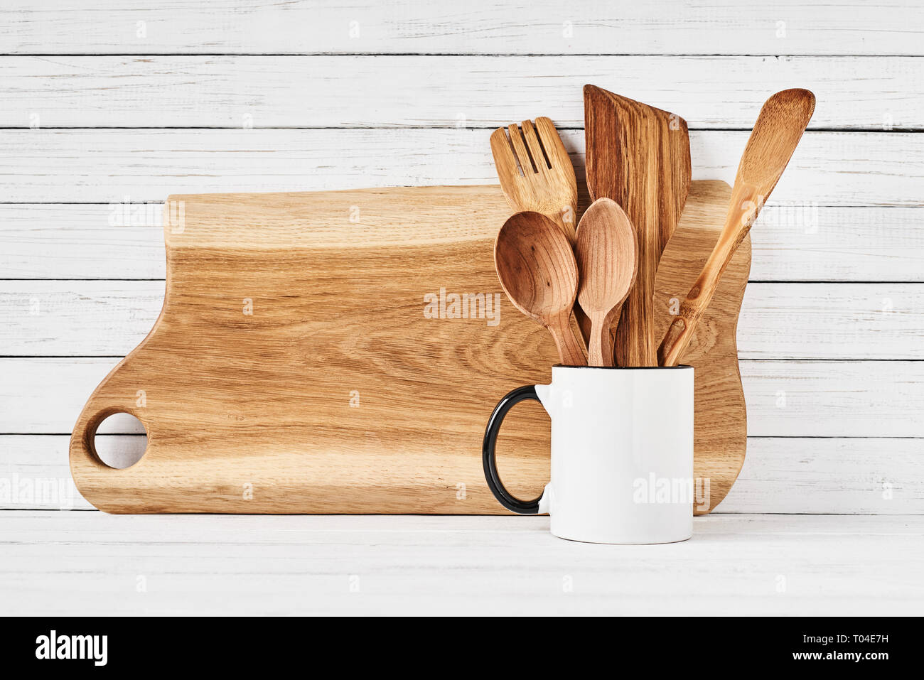 Cooking utensils and cutting board on white table. front view. Kitchen ...