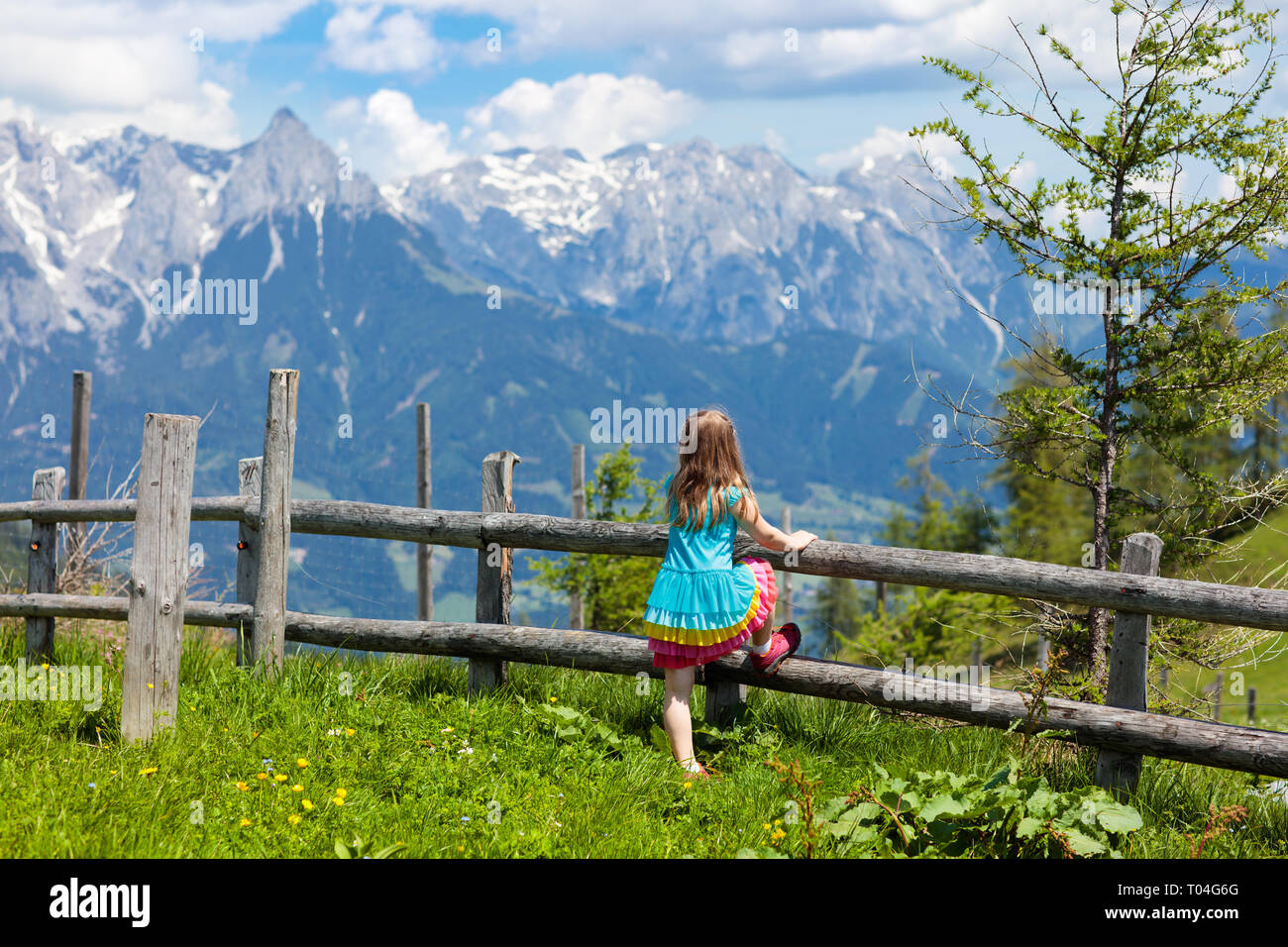 Children hiking in Alps mountains. Kids look at snow covered mountain ...