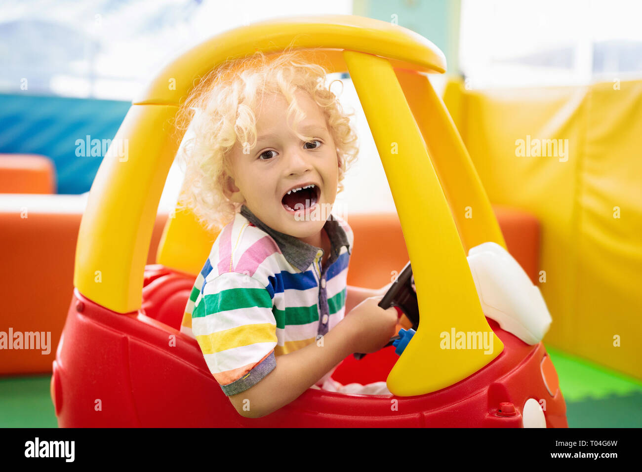 Child riding toy car. Little boy playing with big bus. Kid driving ...