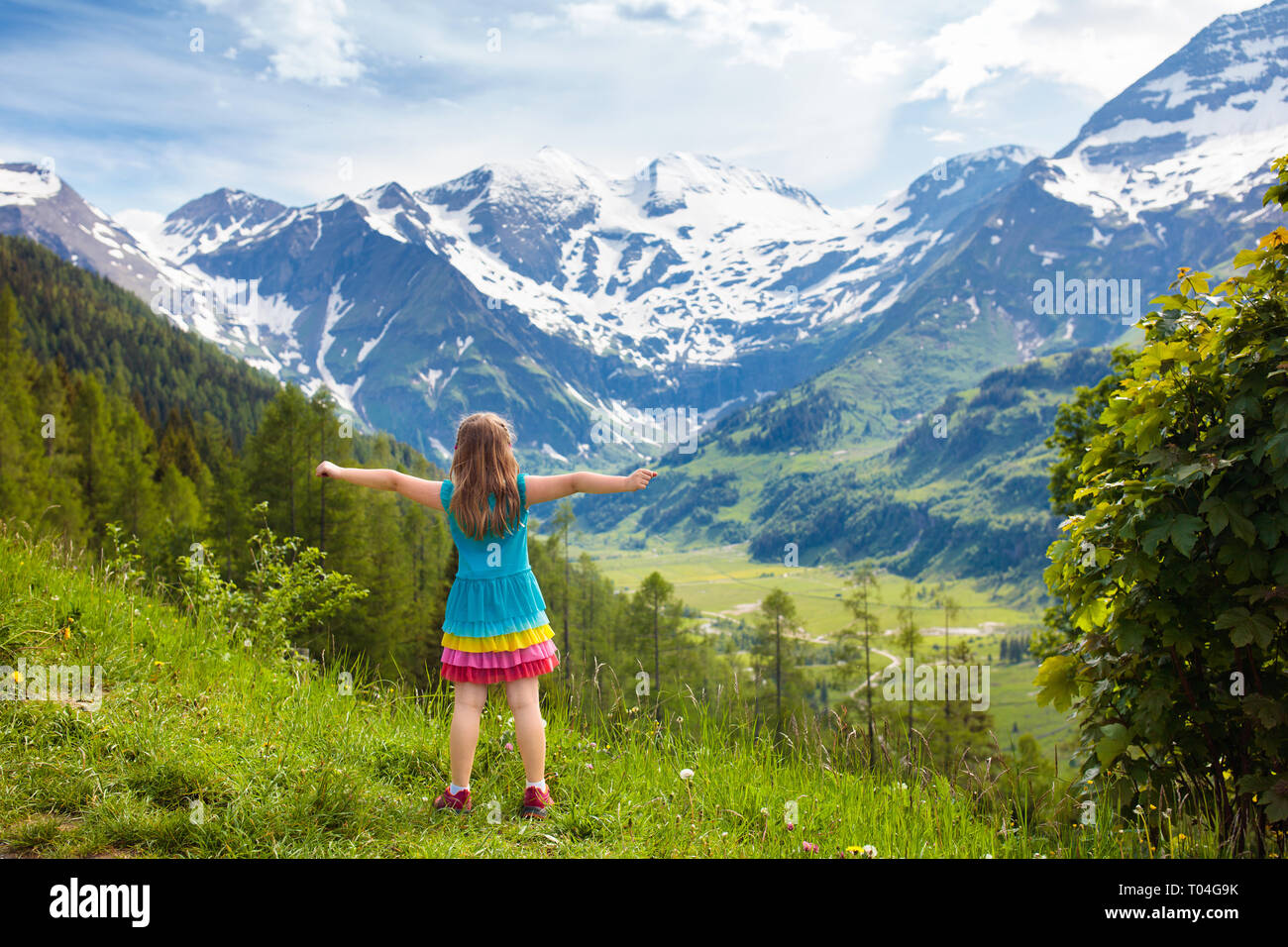 Children hiking in Alps mountains. Kids look at snow covered mountain ...