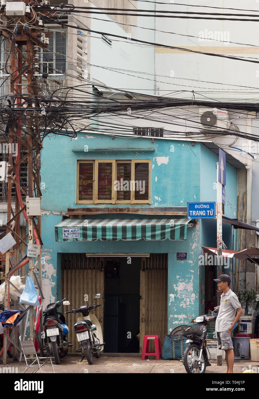 man standing near weathered house facade on street in Vietnam Stock ...