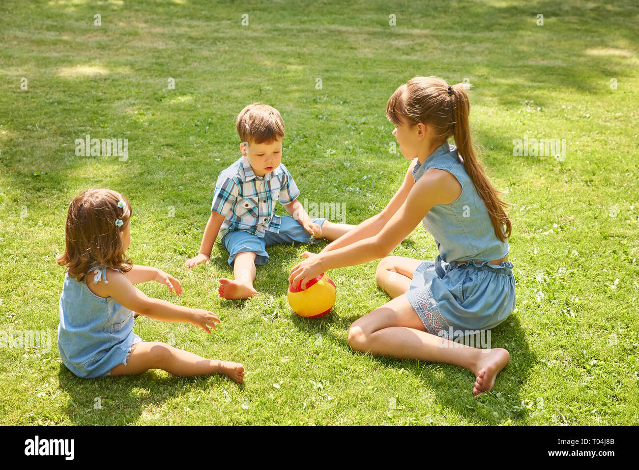 happy playful children outdoors in the summer on grass in a backyard ...