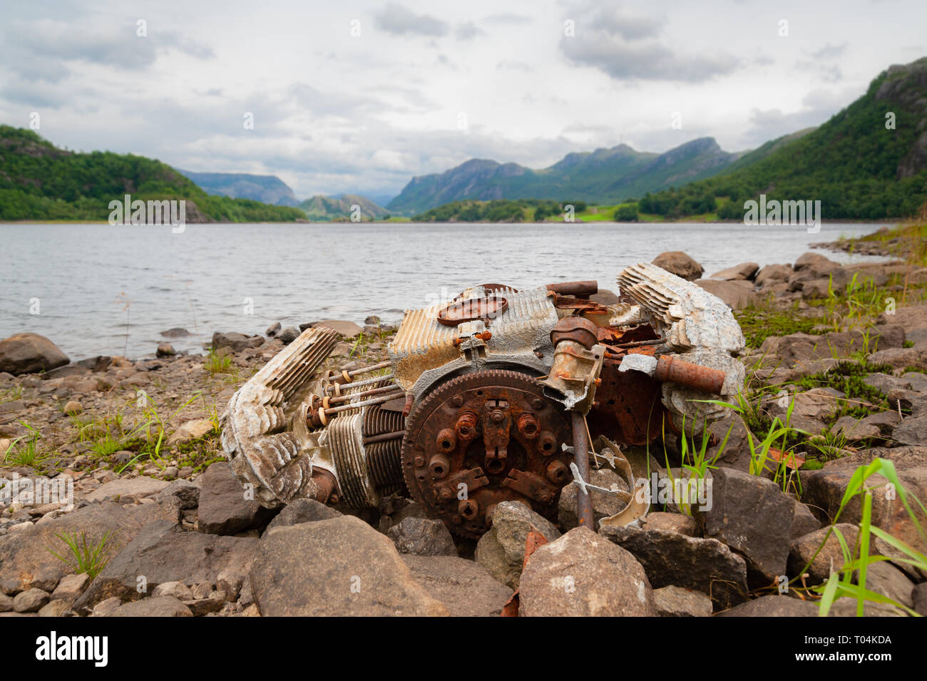 Old rusty car engine left abandoned on the banks of lake / water ...