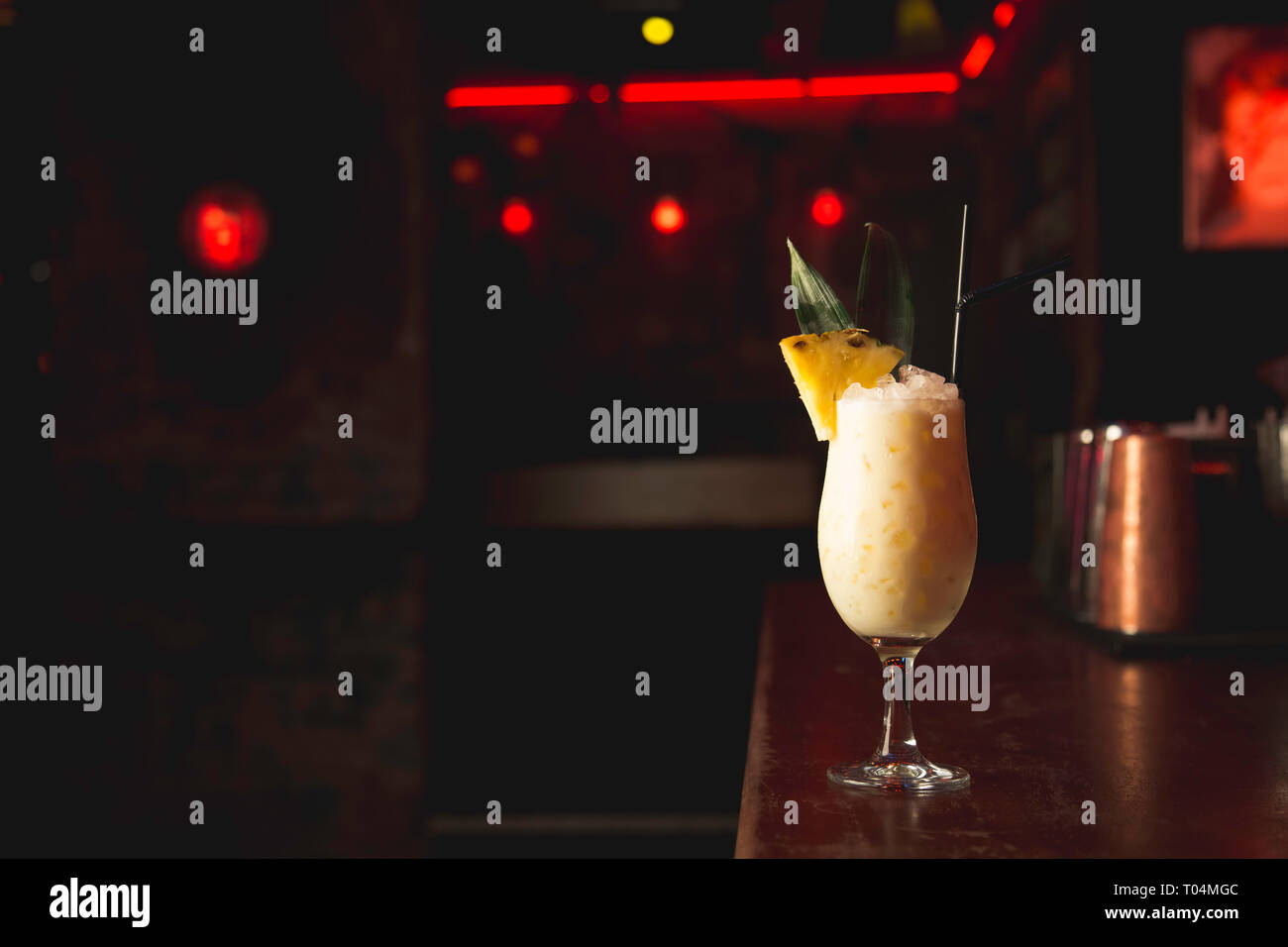 Pina colada cocktail on bar with pineapple garnish Stock Photo - Alamy