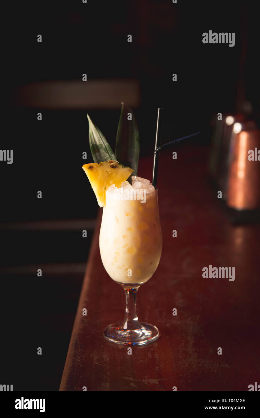 Pina colada cocktail on bar with pineapple garnish Stock Photo - Alamy