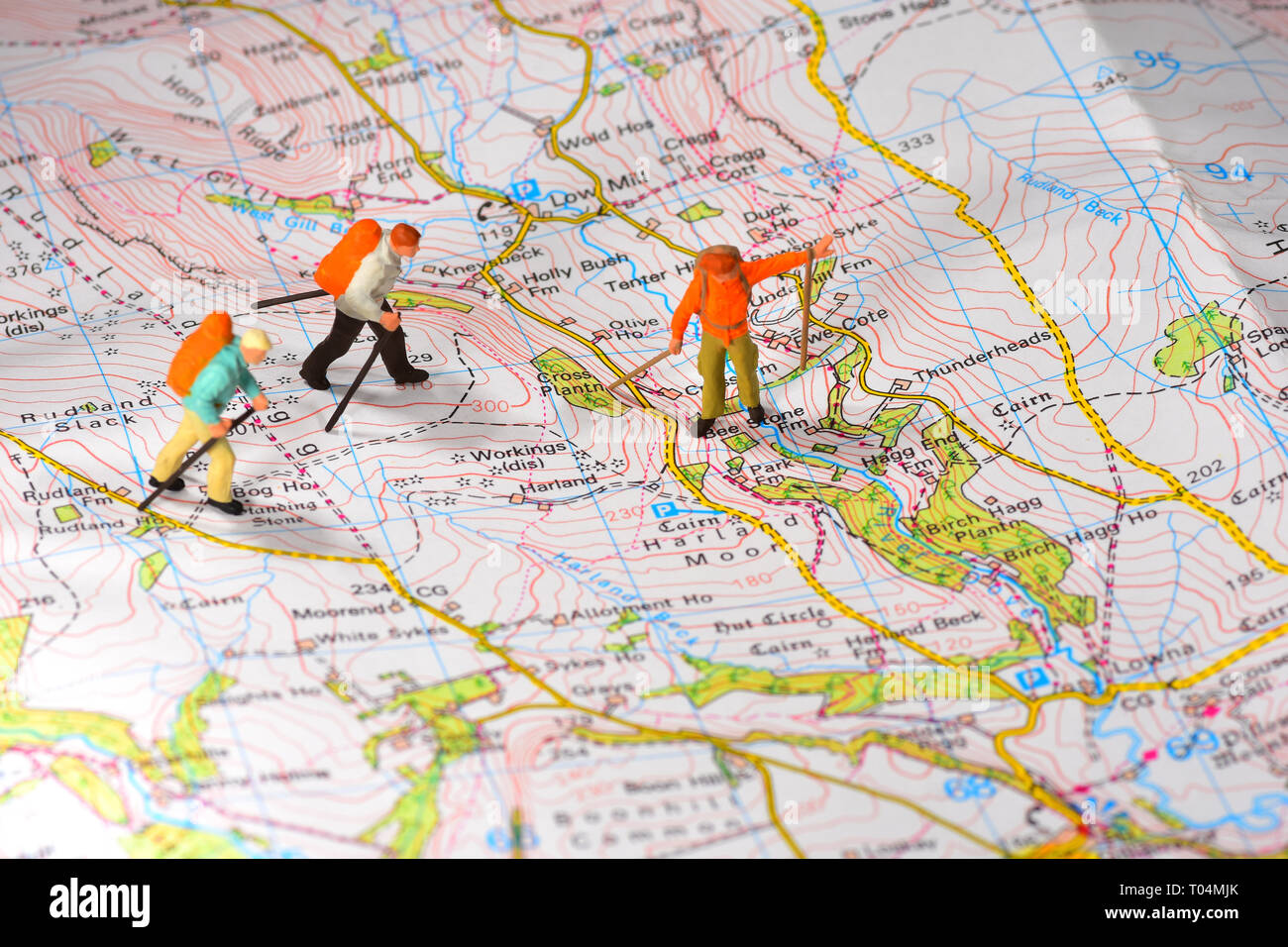 Hikers walking across and Ordinance Survey map Stock Photo - Alamy