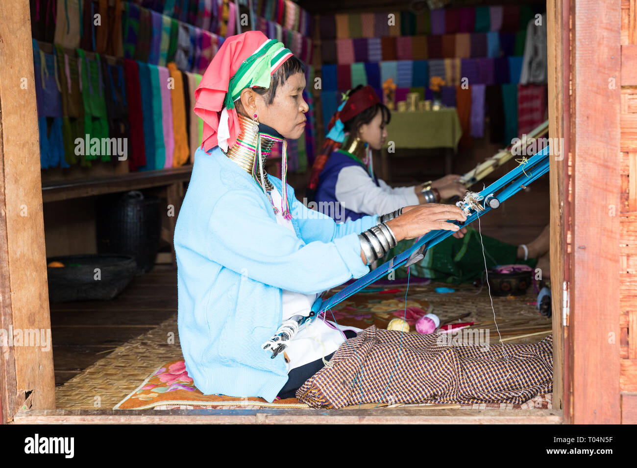Burmese long-neck women making silk from lotus in traditional wooden ...