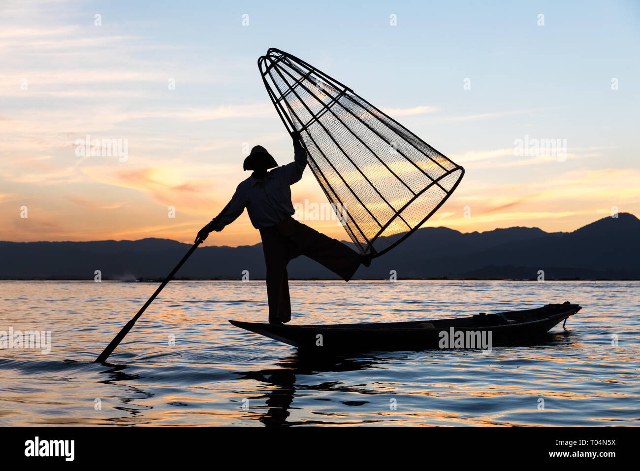 Fishermen fishing with big net in traditional and unique one-leg rowing ...