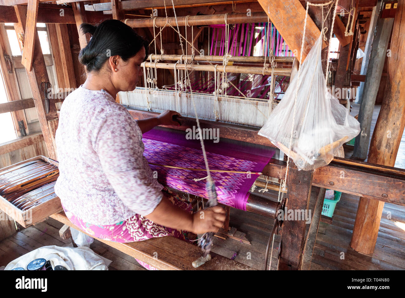 Burmese worker make silk from lotus in traditional wooden weaving and handworking factory in ...