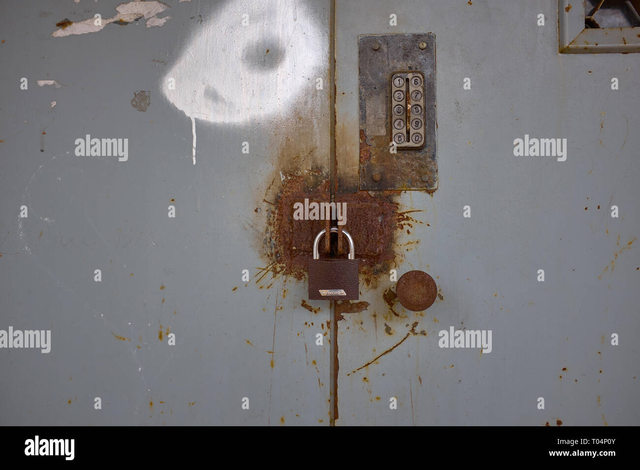 lock on rusty iron grey door with white draw Stock Photo - Alamy