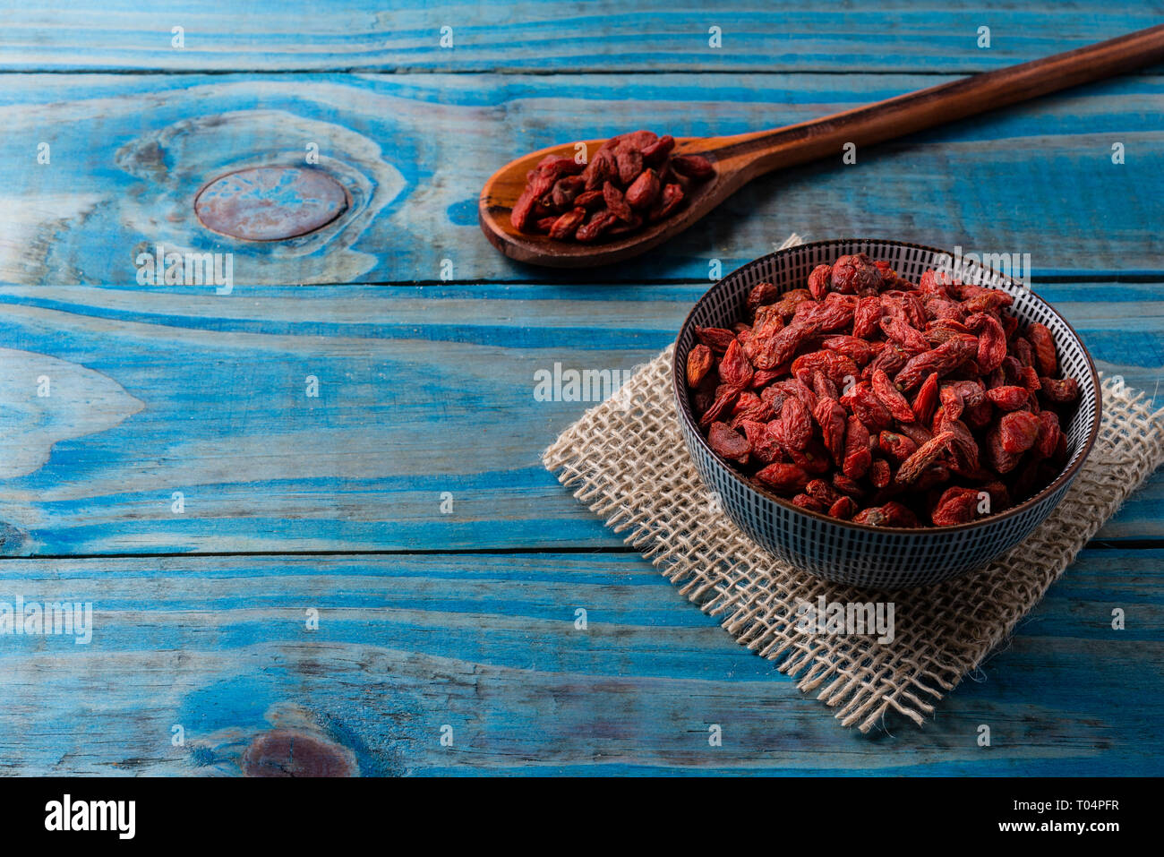 Goji Berry inside ceramic pot on blue pine wood Stock Photo - Alamy
