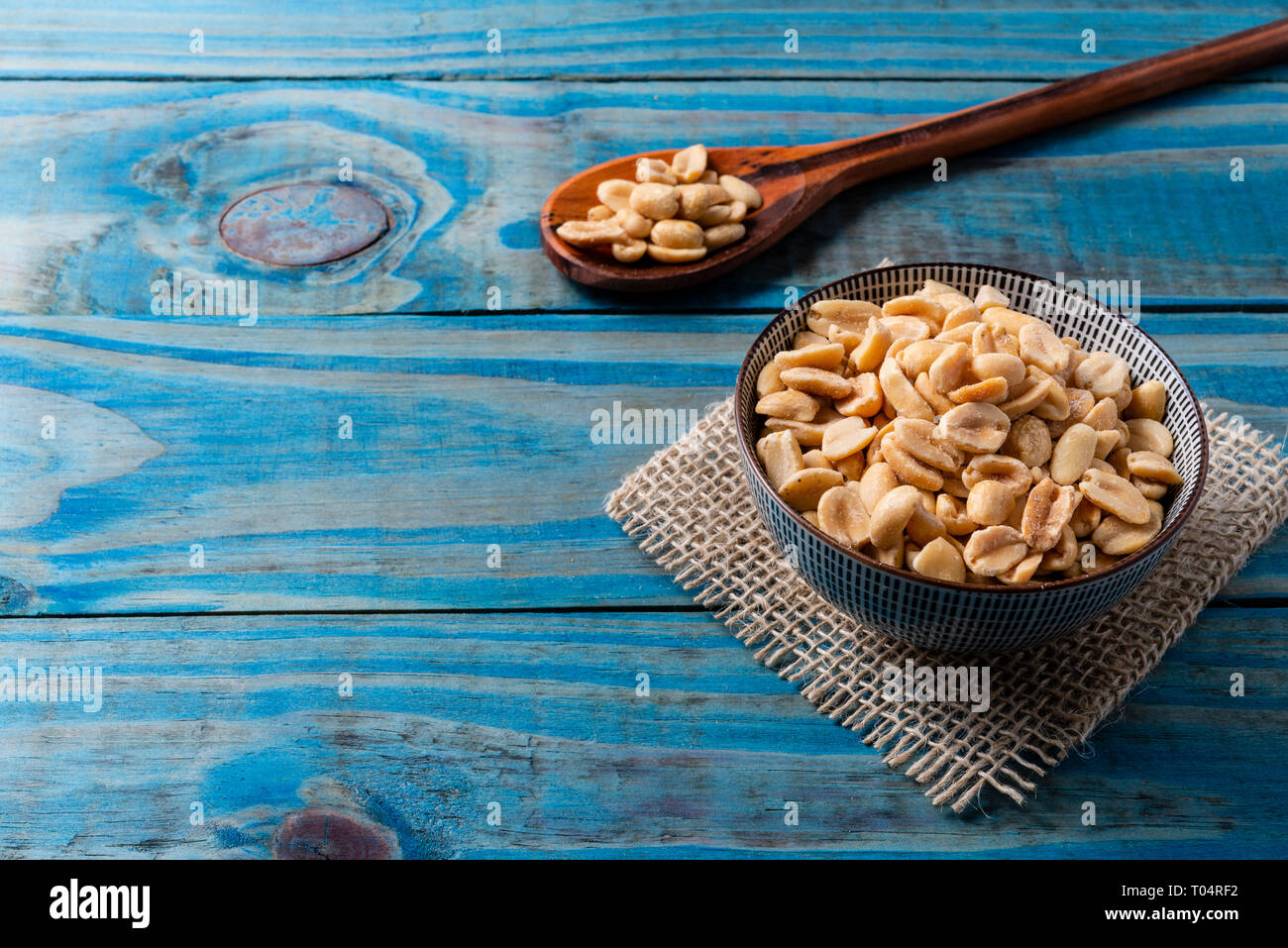 Peanut inside ceramic pot over blue pine wood Stock Photo - Alamy