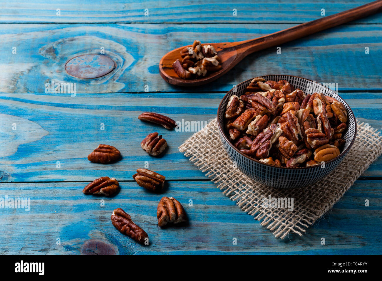 Pecan nuts inside ceramic pot over blue pine wood Stock Photo - Alamy