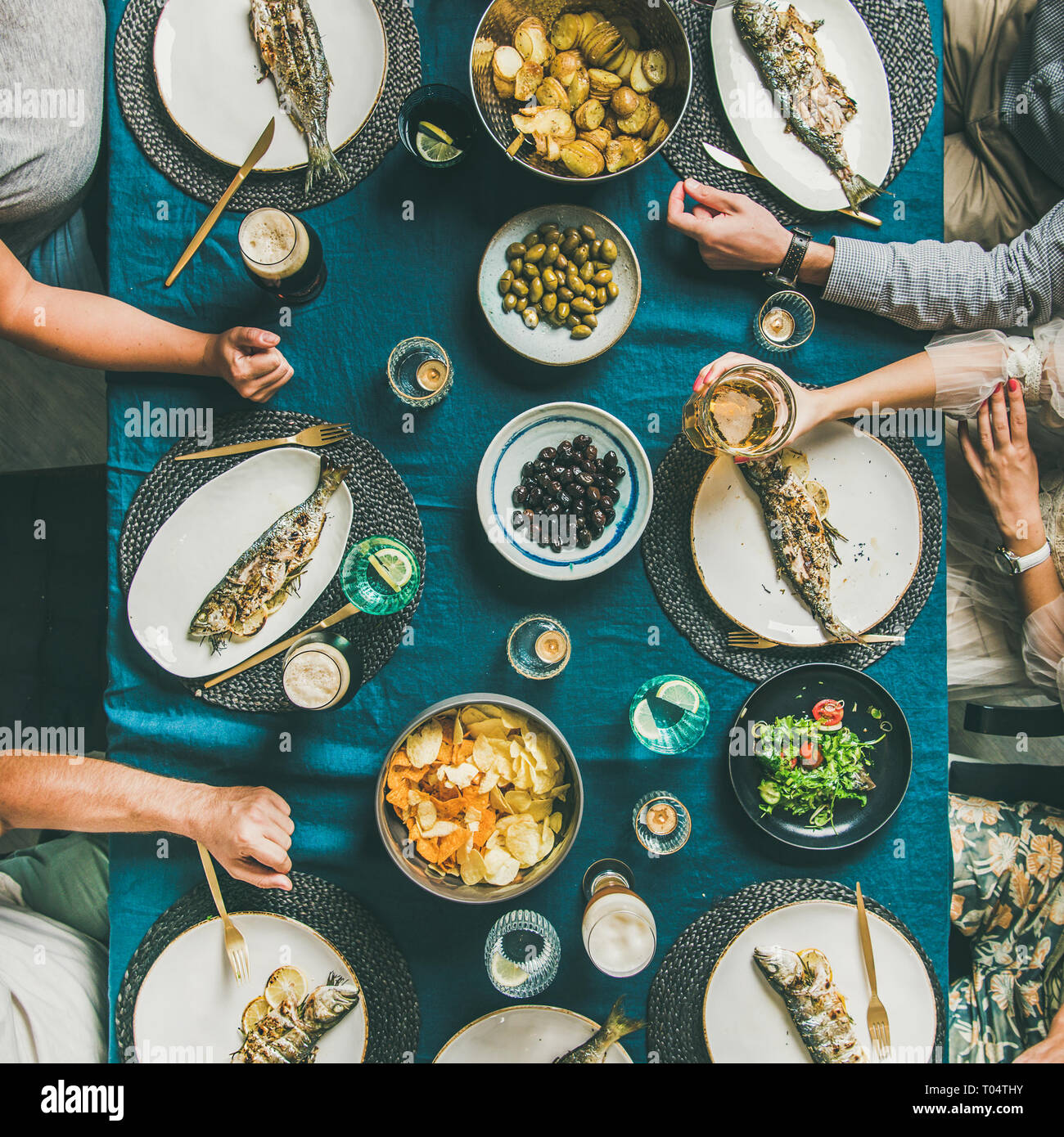 Flat-lay of people eating fish and drinking beer, square crop Stock ...