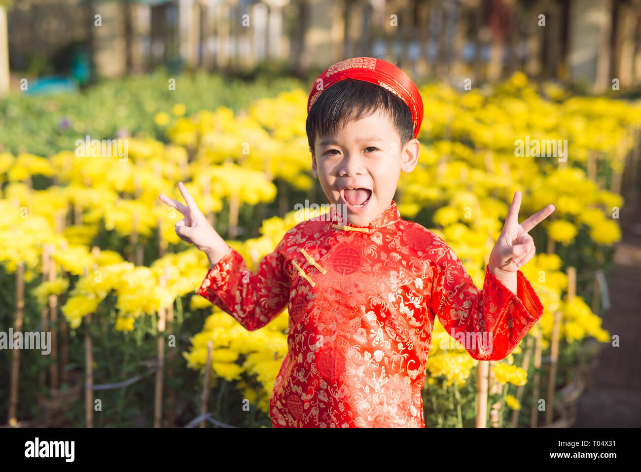 Having fun asian kid at marigold garden. Portrait of funny kid wearing ...