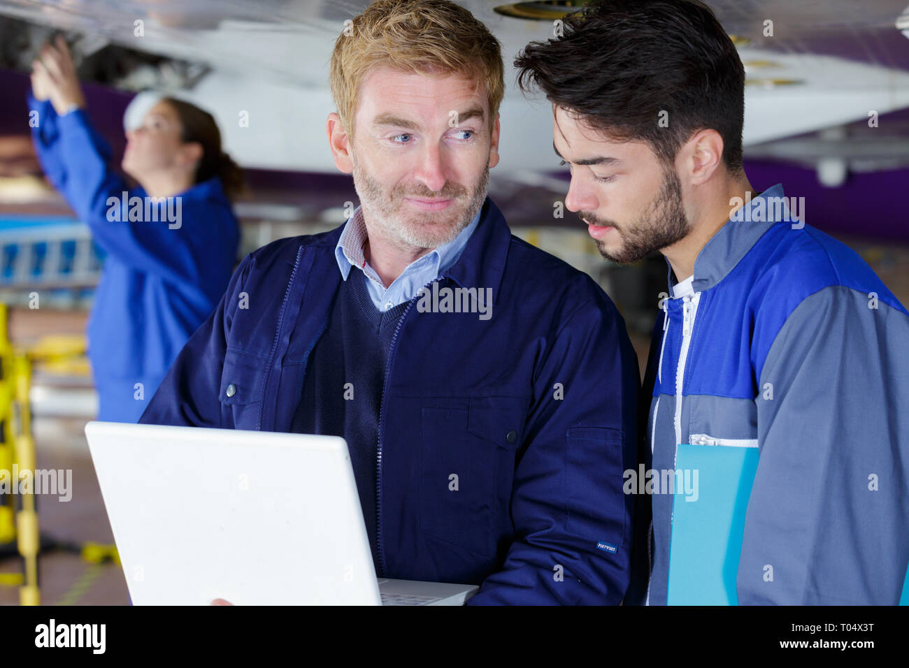 engineering teacher checking airplane engines with his student Stock ...