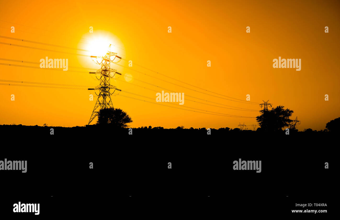 beautiful sunset over power line with green fields in punjab,pakistan ...