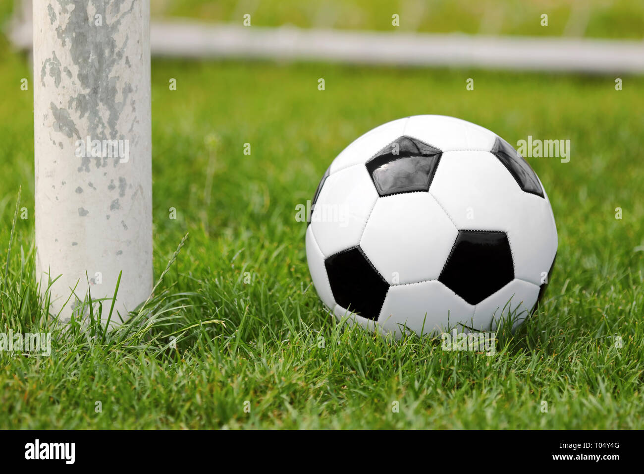 Soccer ball on football green field with gate Stock Photo - Alamy