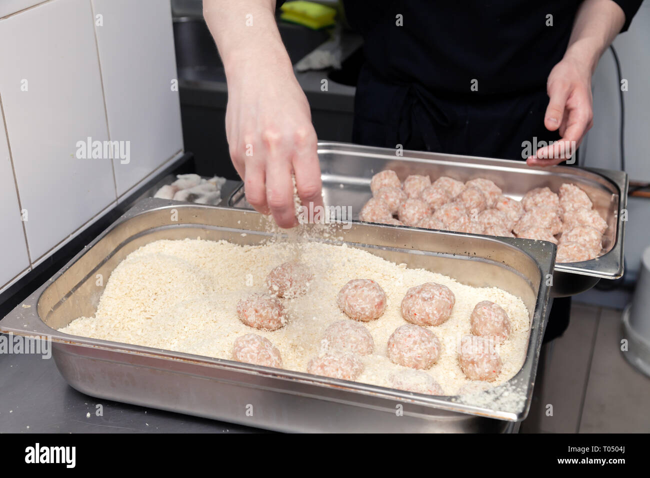 Chef hands creating, forming, breading chicken cutlets with knife on ...