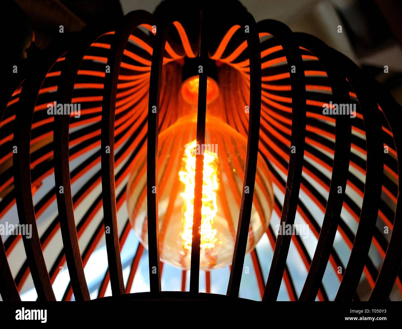 Curved light fixture with lit light bulb Stock Photo - Alamy