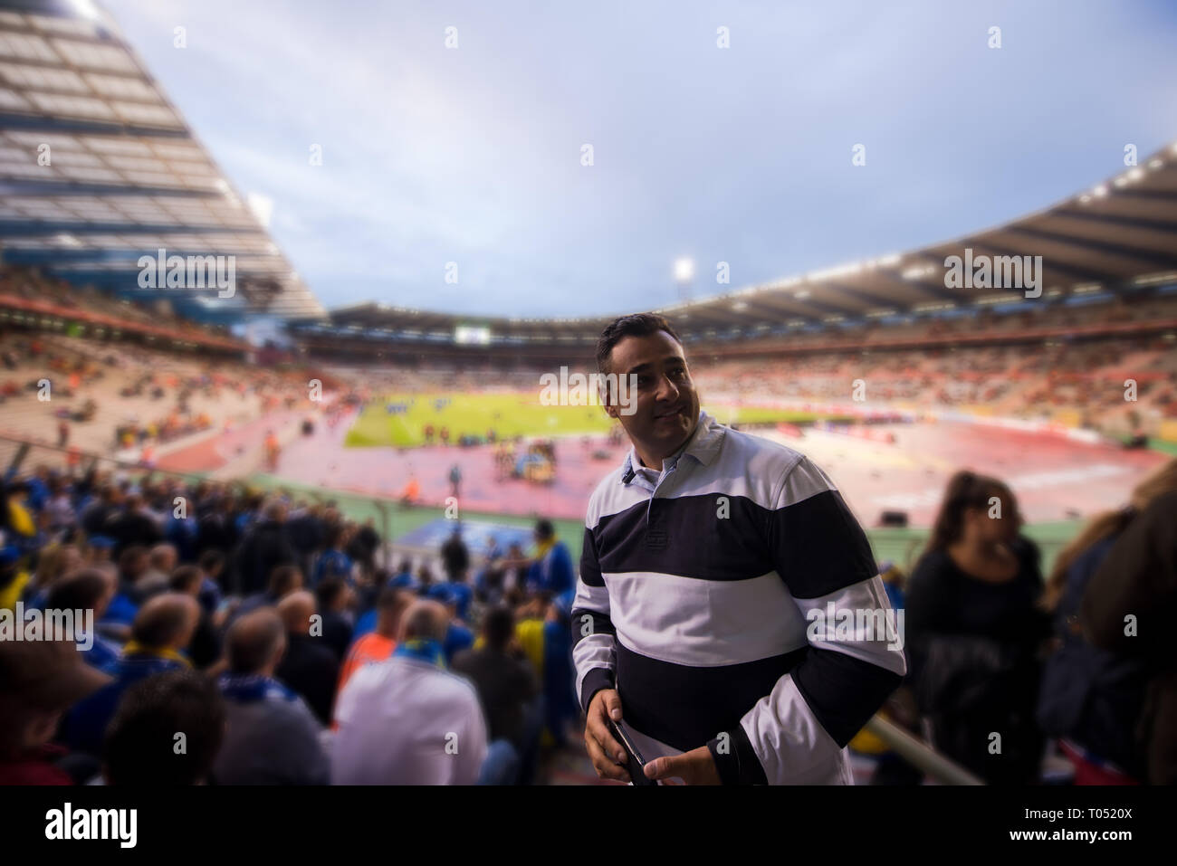 portrait of a male football fan standing on the stadium while ...