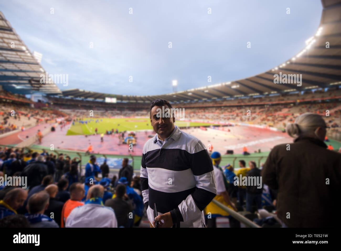 portrait of a male football fan standing on the stadium while ...