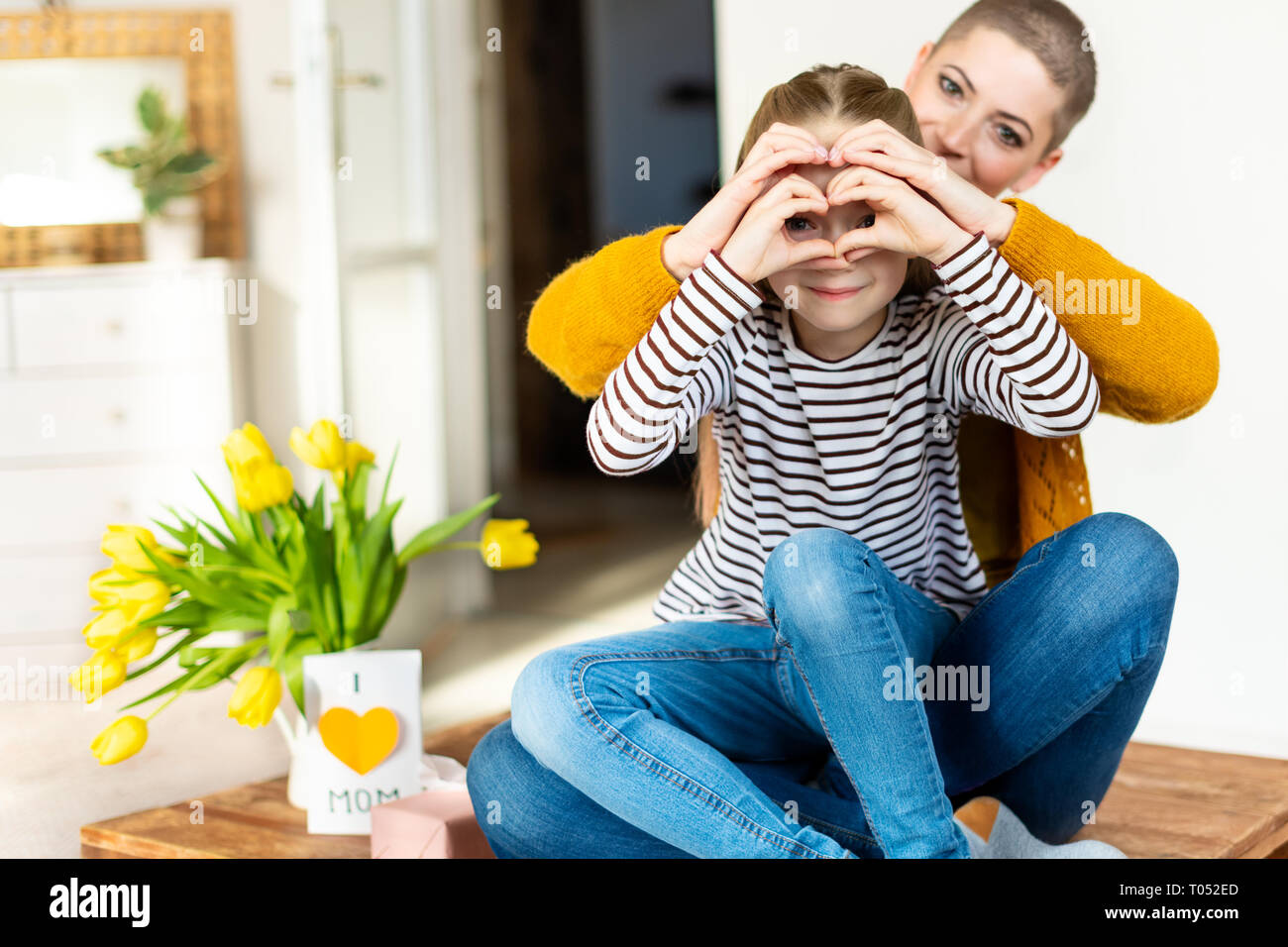 Mother and daughter looking through heart shaped love symbol hand ...
