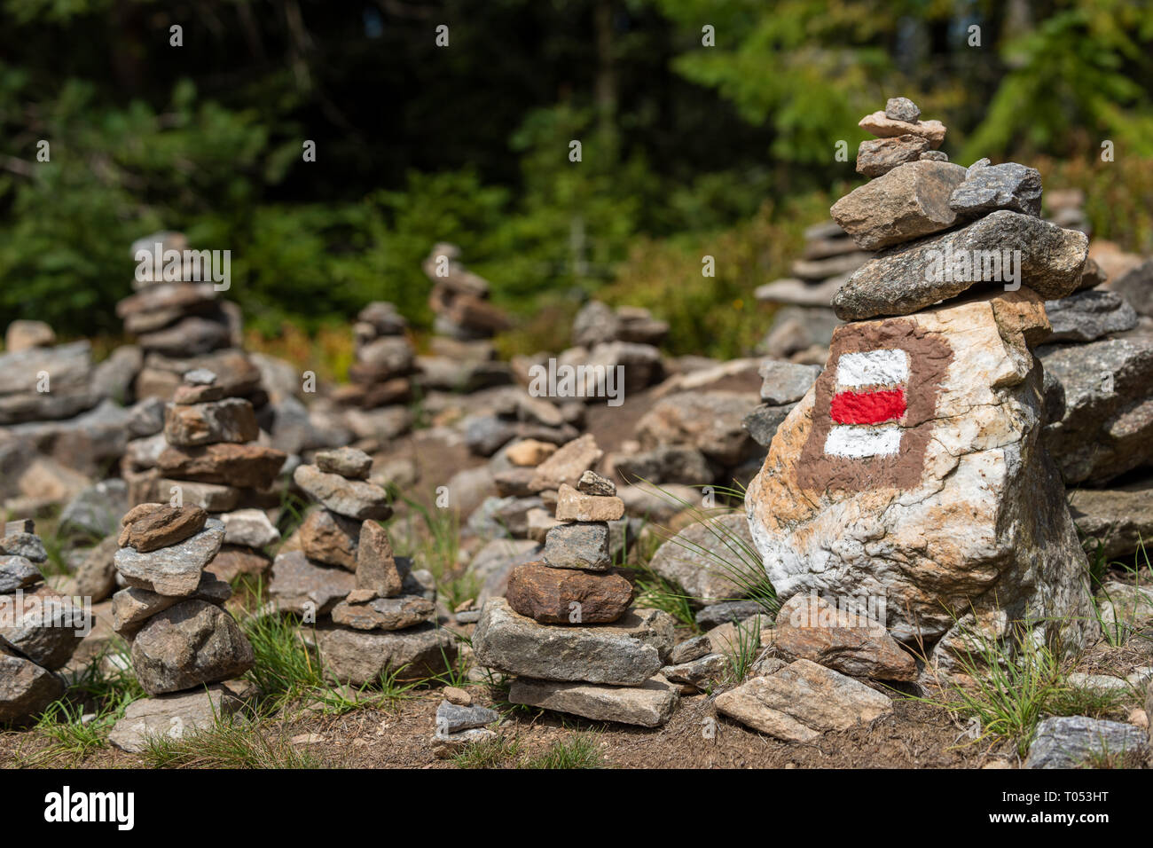 Hiking trail sign mark painted on a rock in stack of zen stones. Path ...