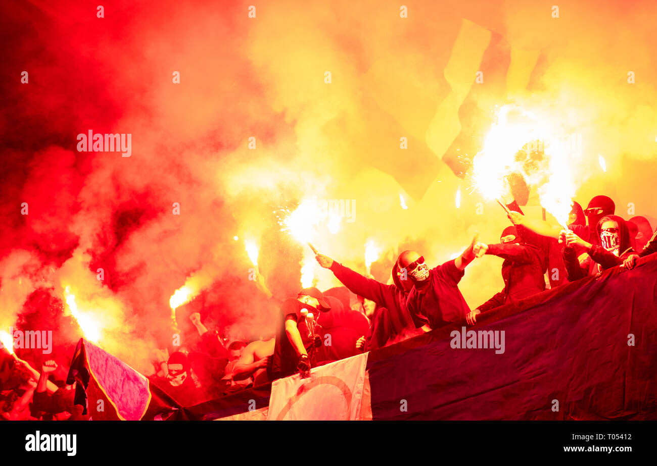 Football Hooligans With Mask Holding Torches In Fire While Supporting