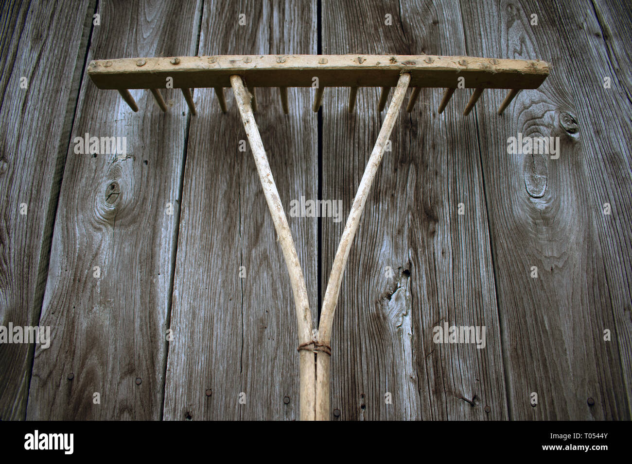 Old wooden rakes with wooden board background Stock Photo - Alamy