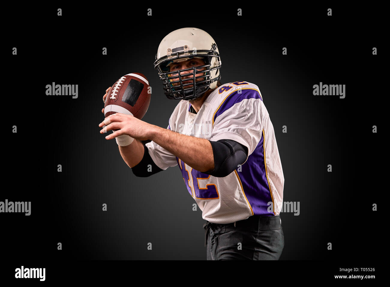 American football player in uniform with the ball is preparing to make ...