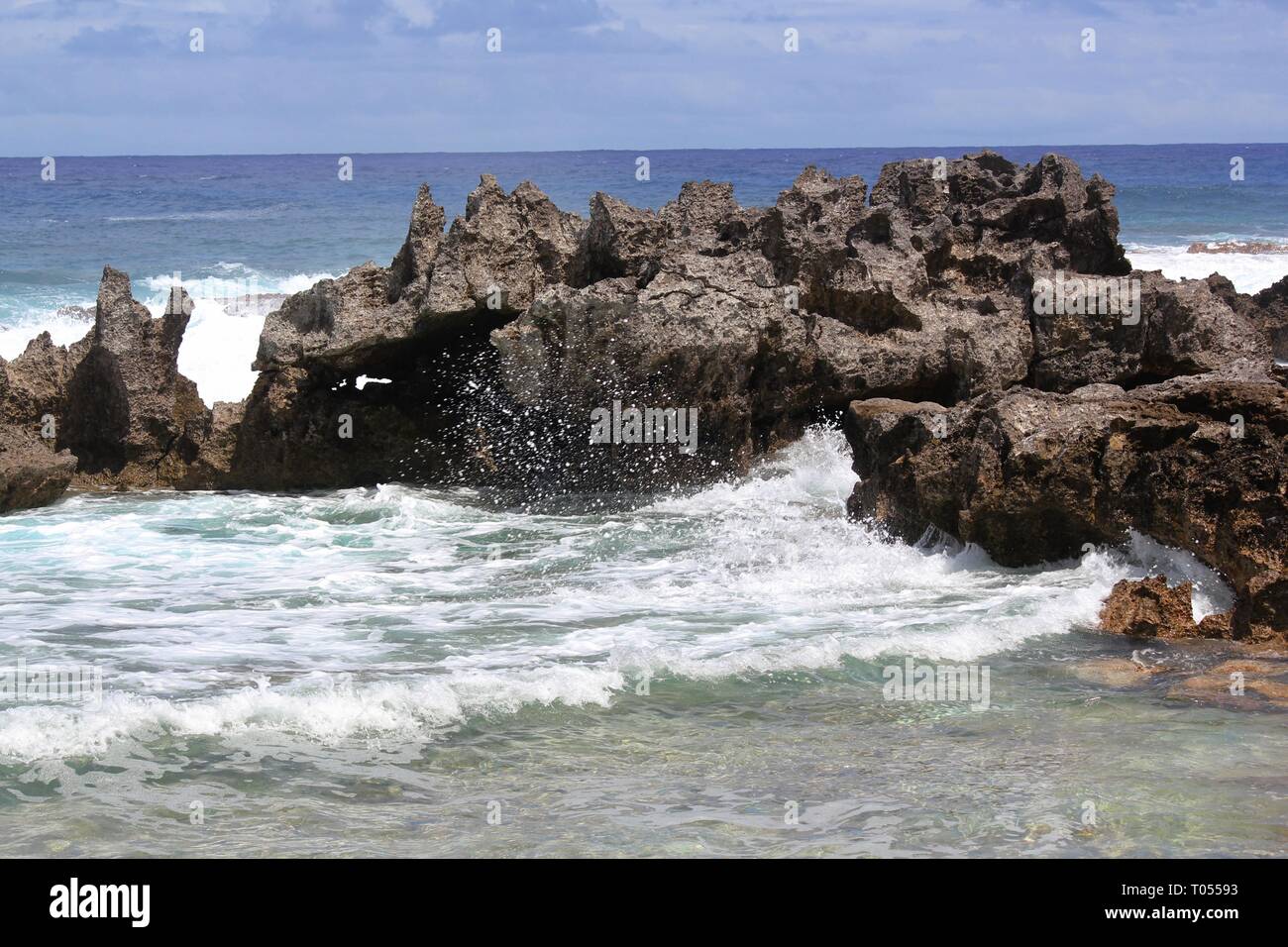 Sharp rocks and corals protecting a swimming cove from the direct waves ...