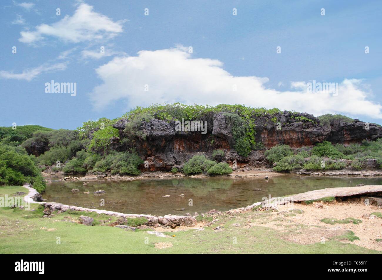 Small pool of overflow water from the Inarajan Lagoon bordered by rocky ...