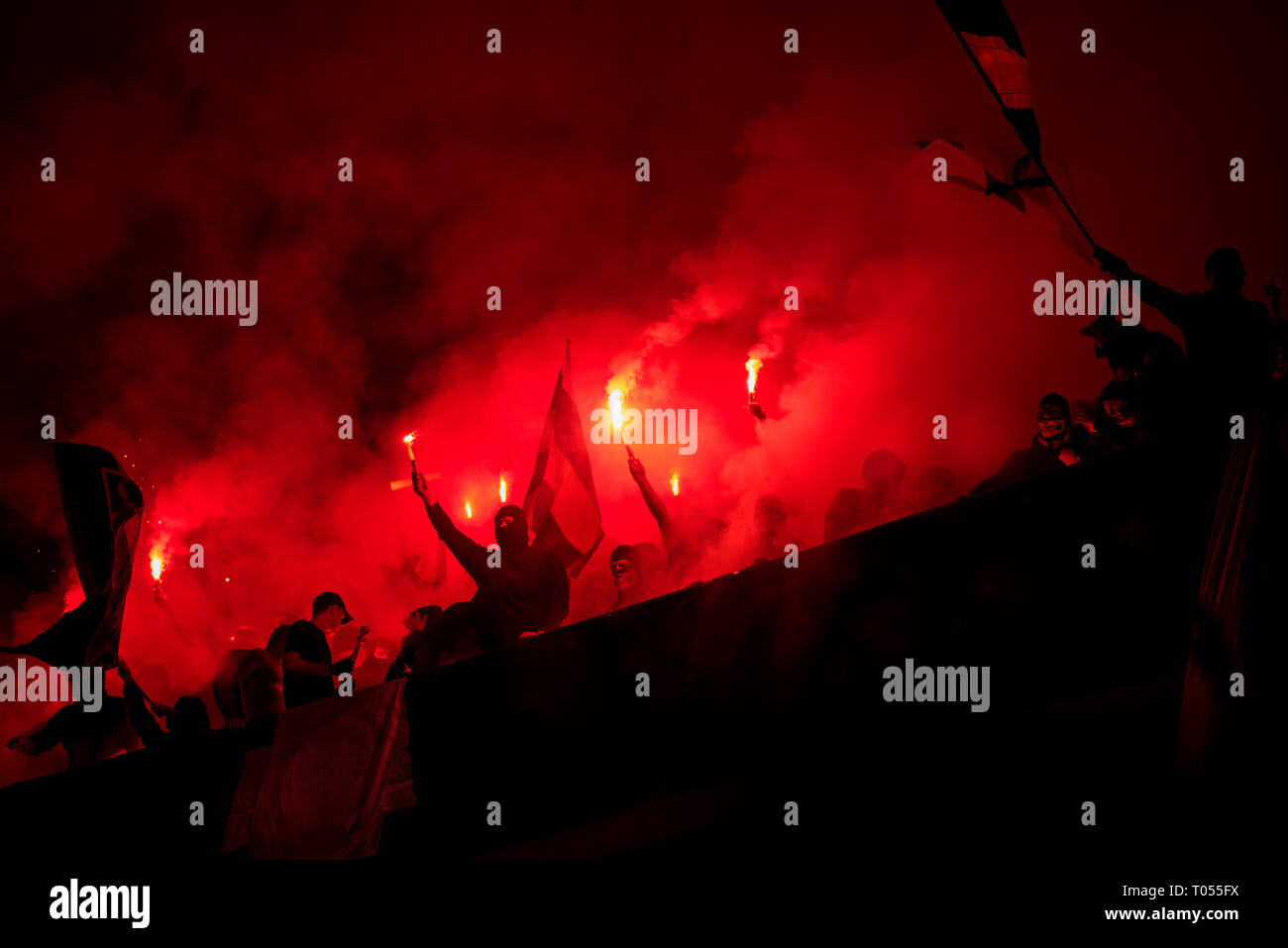 Football Hooligans With Mask Holding Torches In Fire While Supporting
