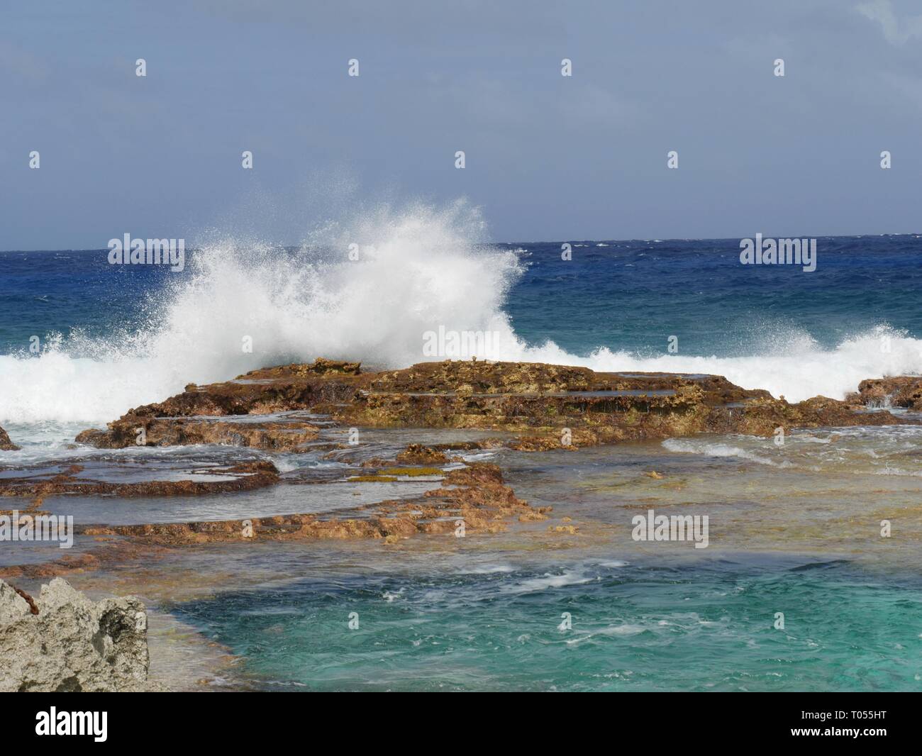 Powerful splash of waves breaking agains the sharp coral stage at the ...