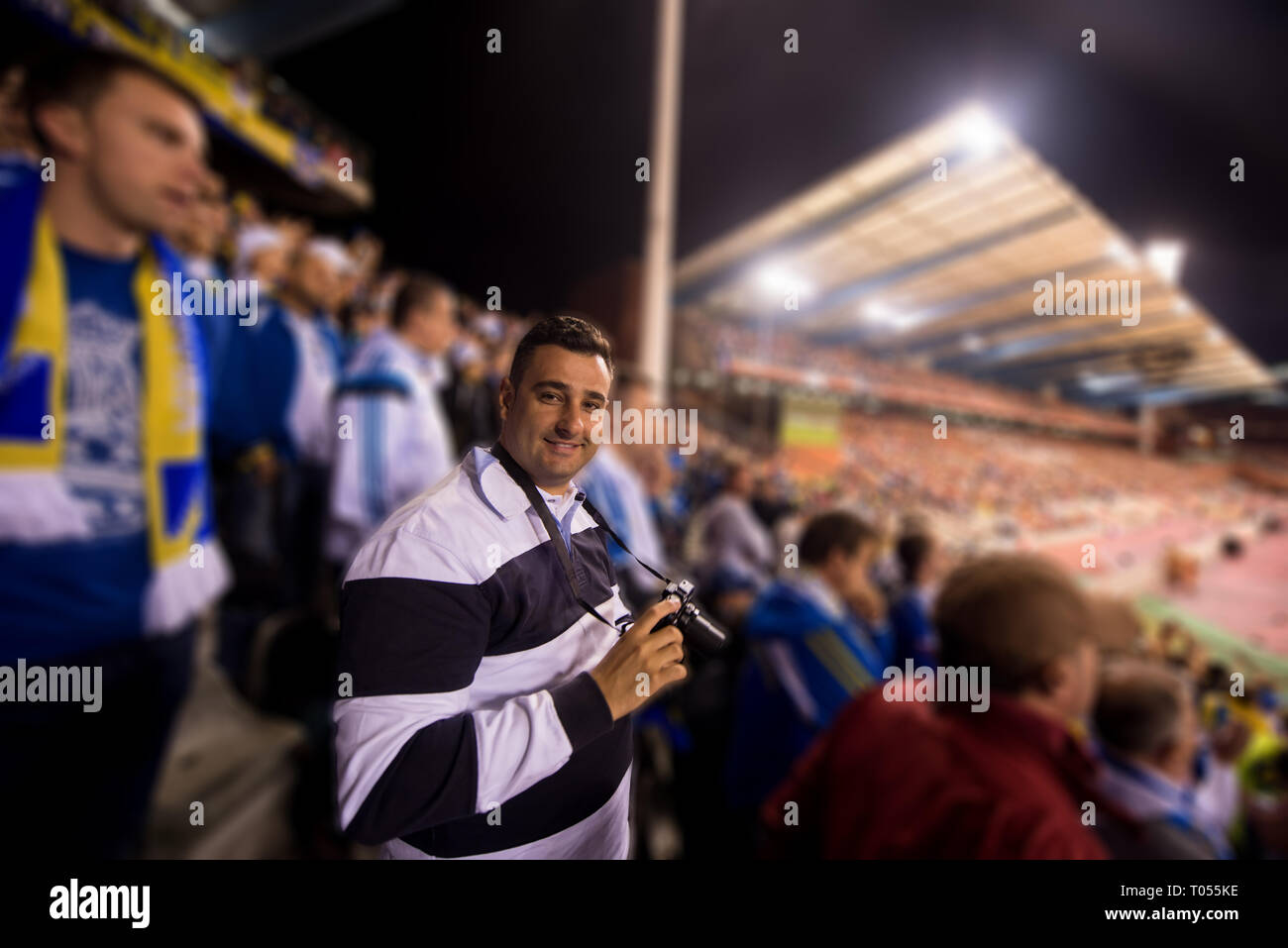 portrait of a male football fan standing on the stadium while ...