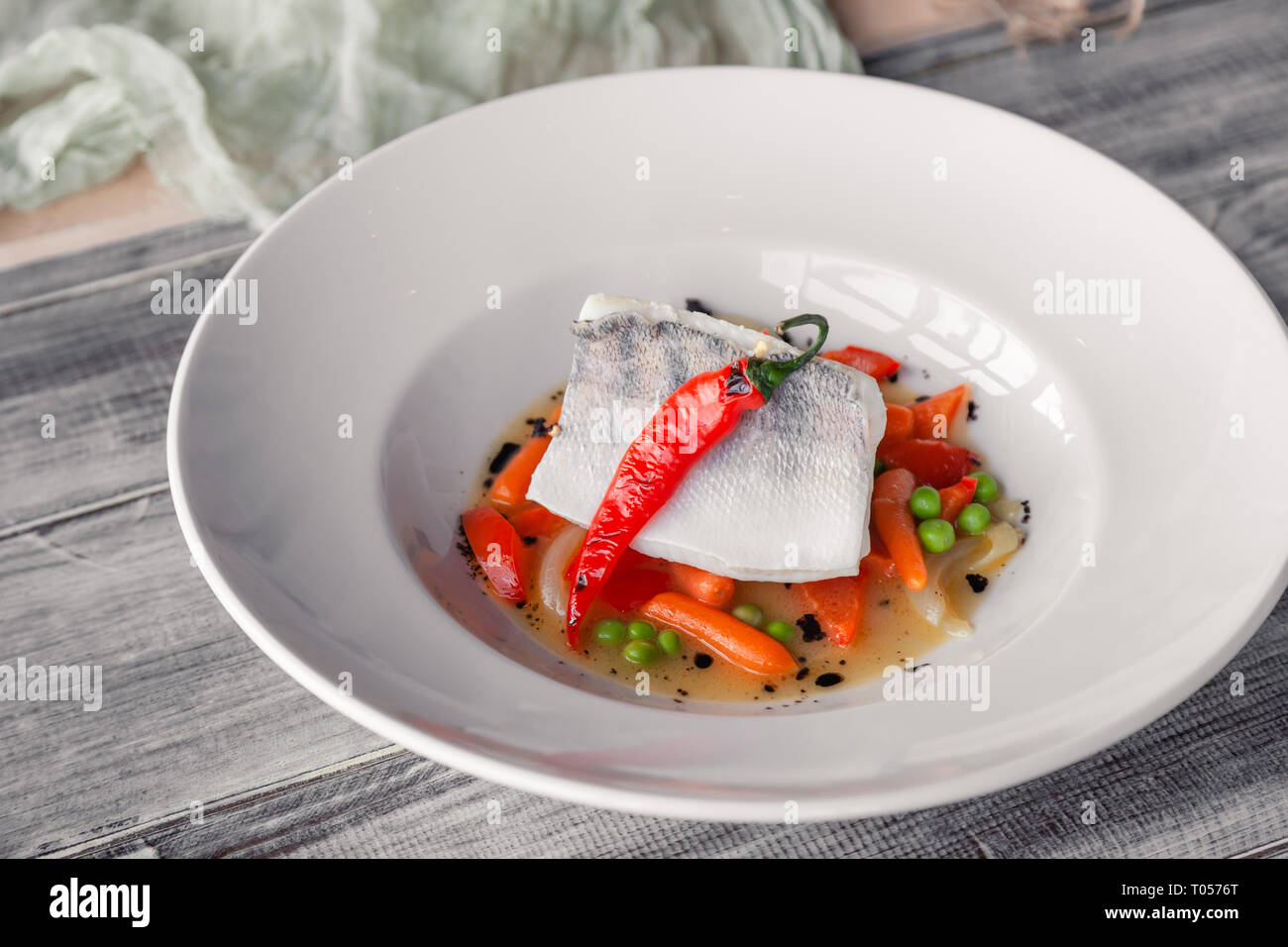 Closeup fillet stewed pike perch with vegetables, chilli pepper, tomato ...