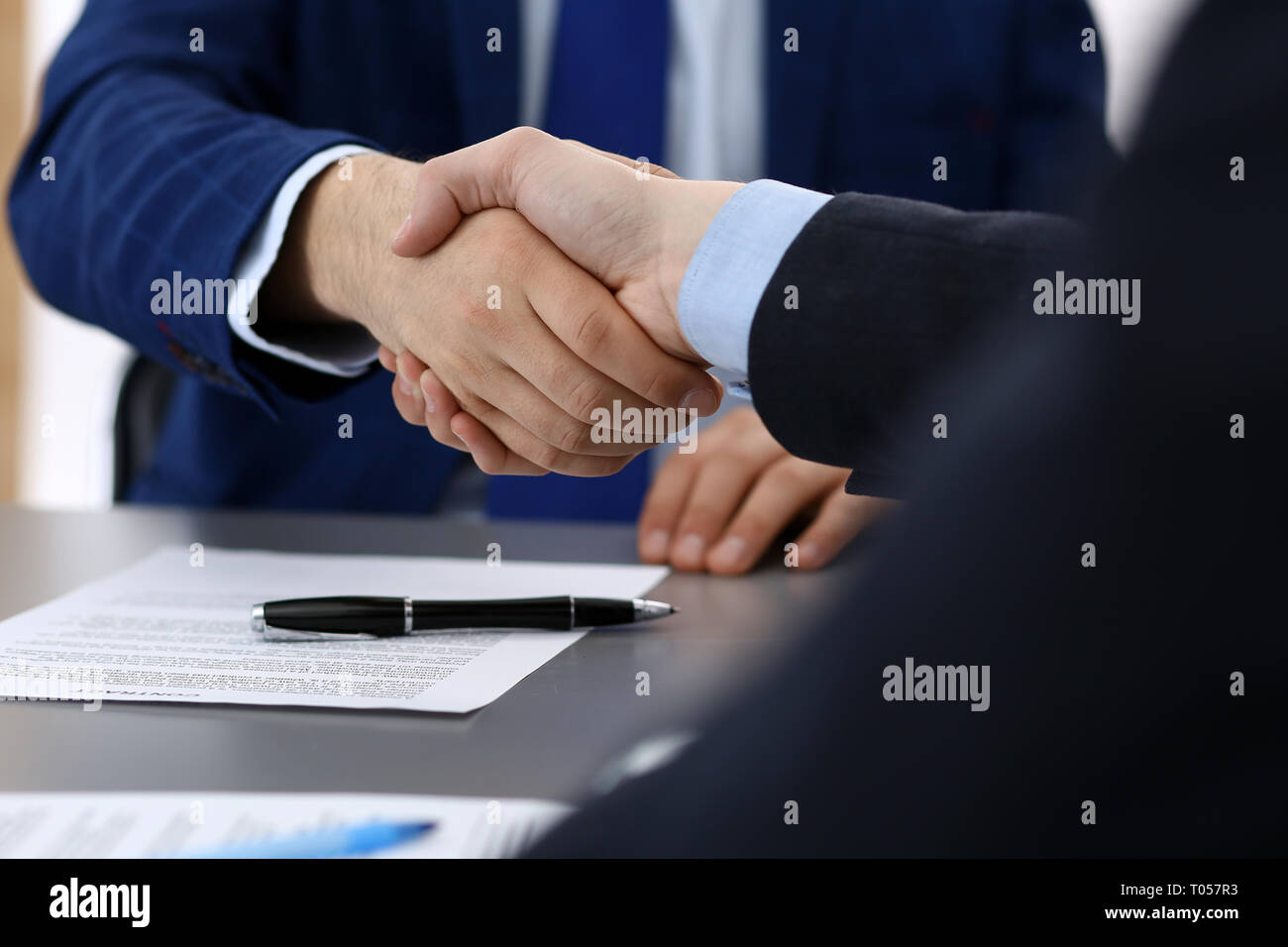 Business people shaking hands, finishing up a papers signing. Meeting ...