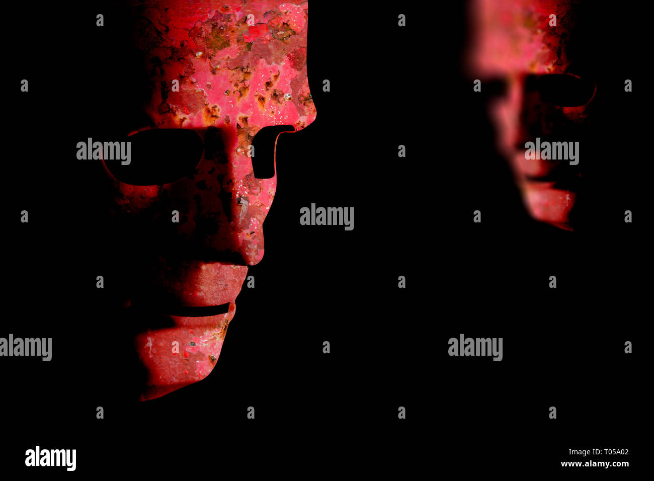 Two robot faces with red rusting decaying skin showing old technology ...