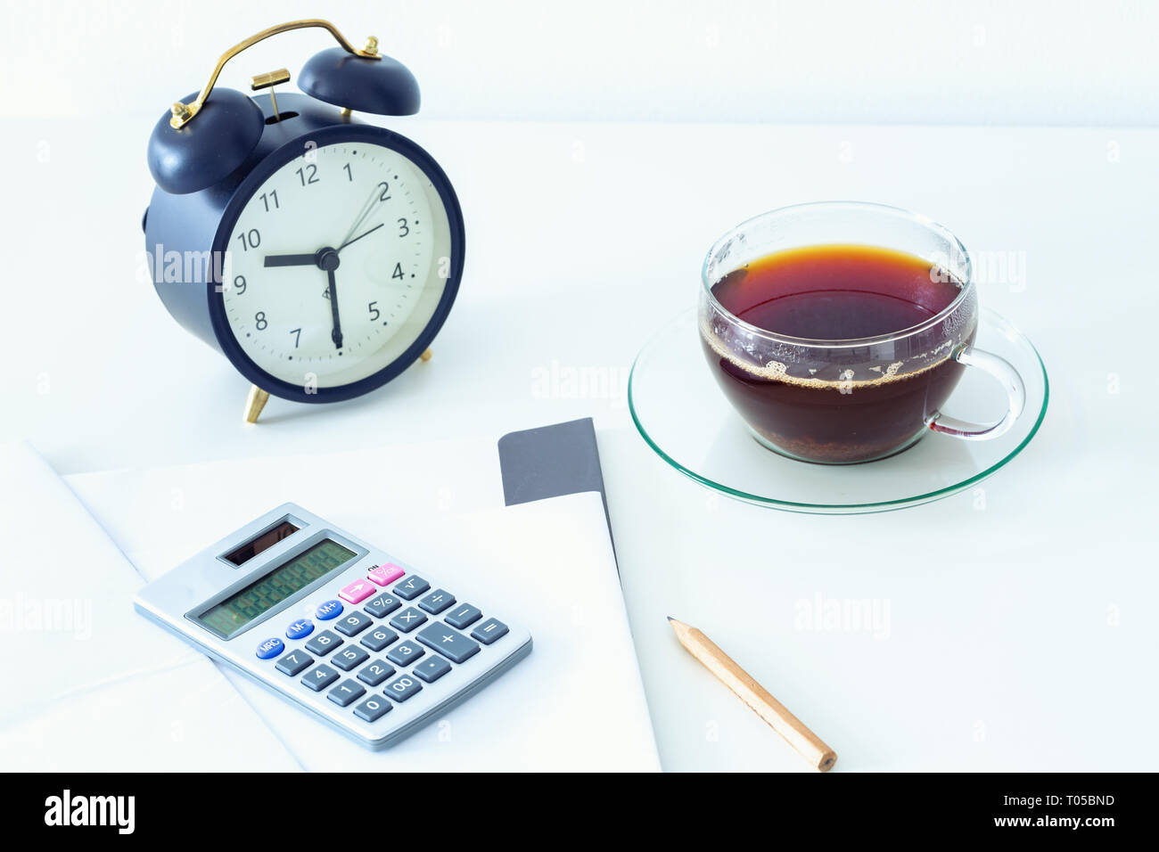 a work desk with a computer and office accessories and an alarm clock ...